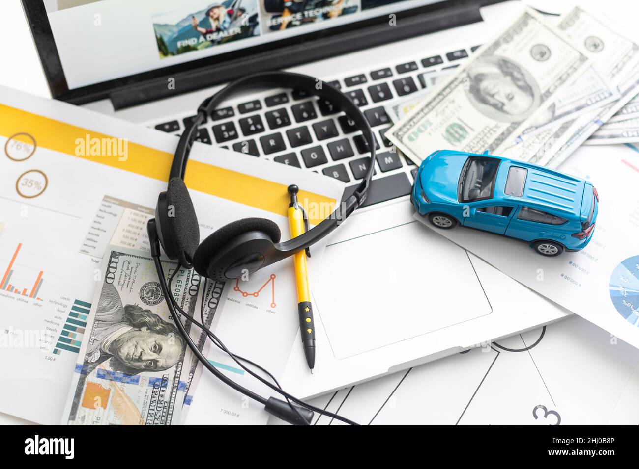toy car with dollars is on the laptop. The programmer Stock Photo - Alamy