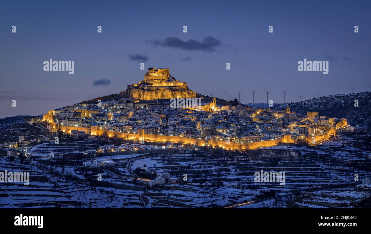 Morella medieval city in a winter twilight and night, after a snowfall ...