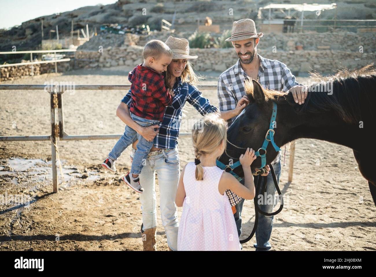 Happy family with horse having fun at farm ranch - Soft focus of father ...