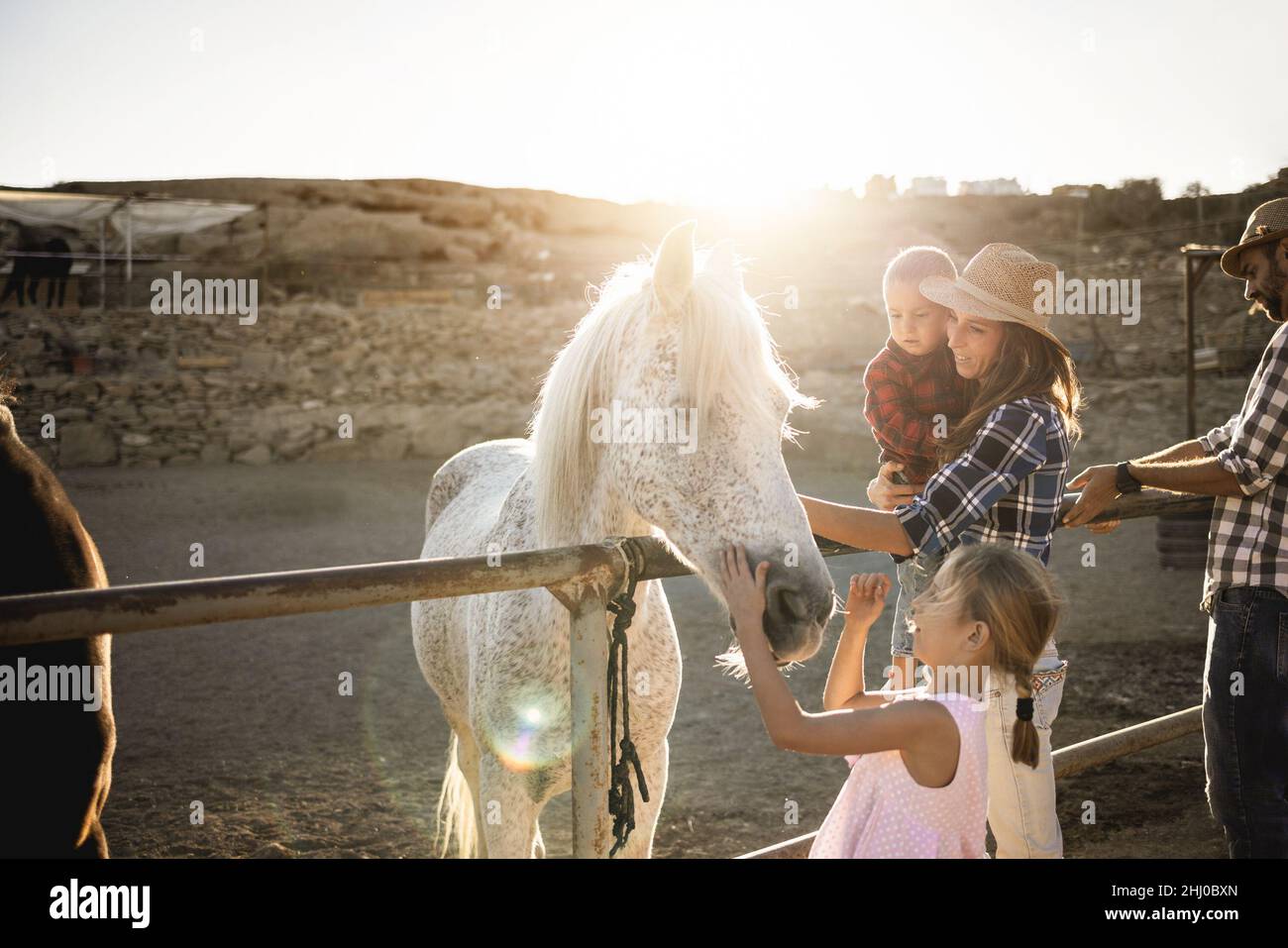 Happy family with horse having fun at farm ranch - Soft focus of mother ...