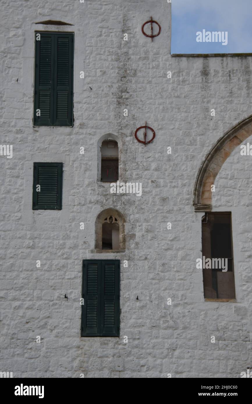 Random windows on a white wall inside the old town of Ostuni, also ...