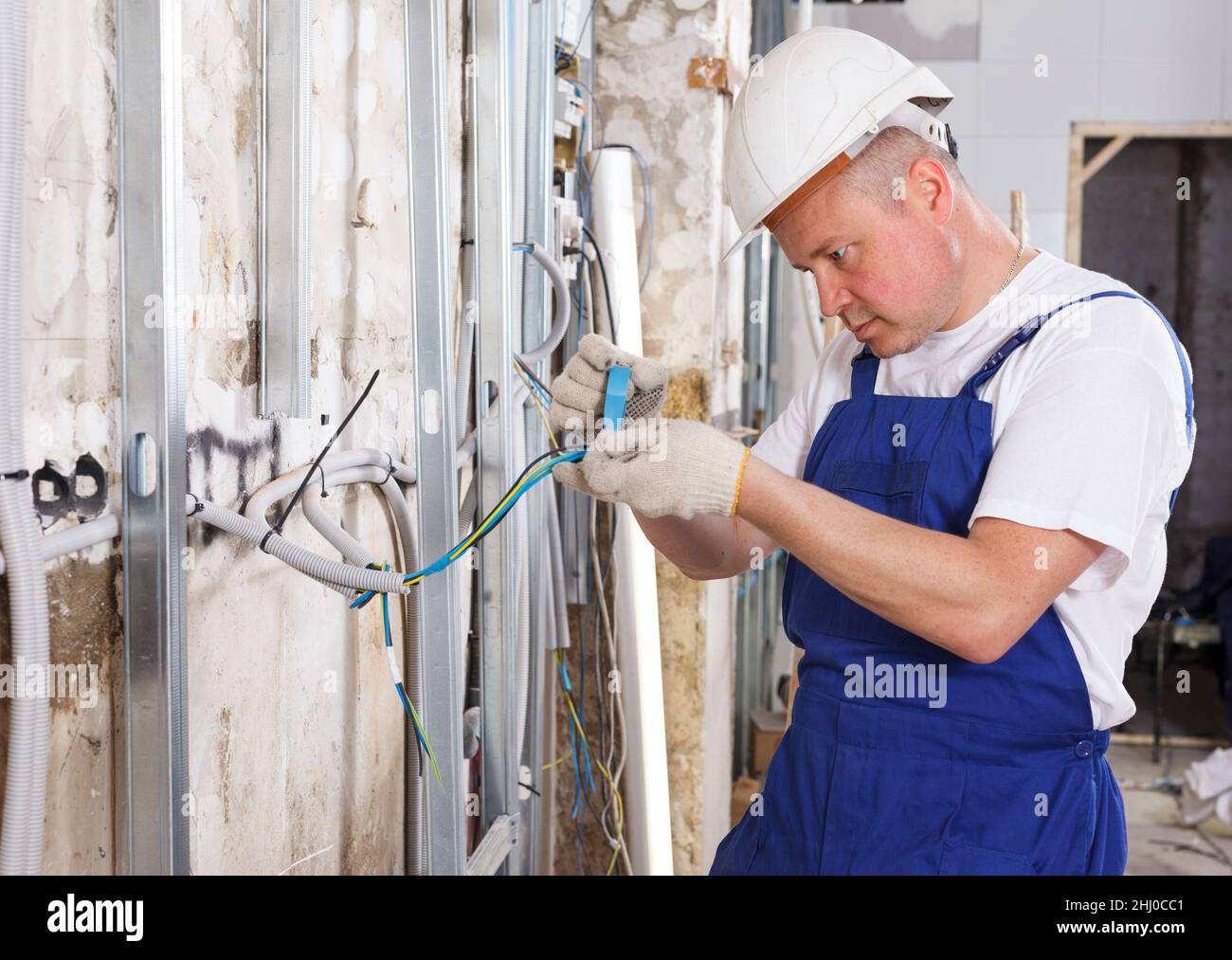 Builder engaged in electrical installation work Stock Photo - Alamy