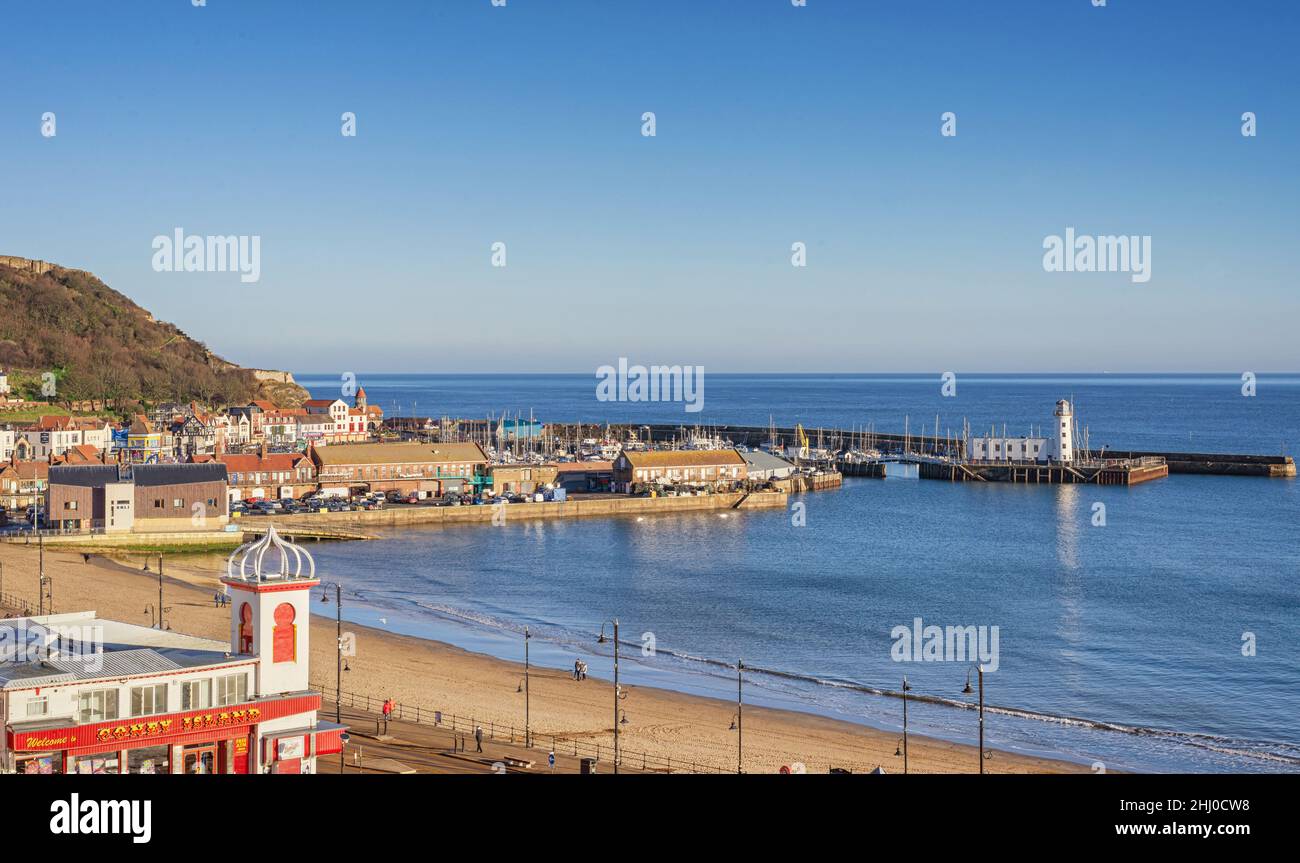 View of seaside bay. A pier stretches out to a lighthouse and an ...