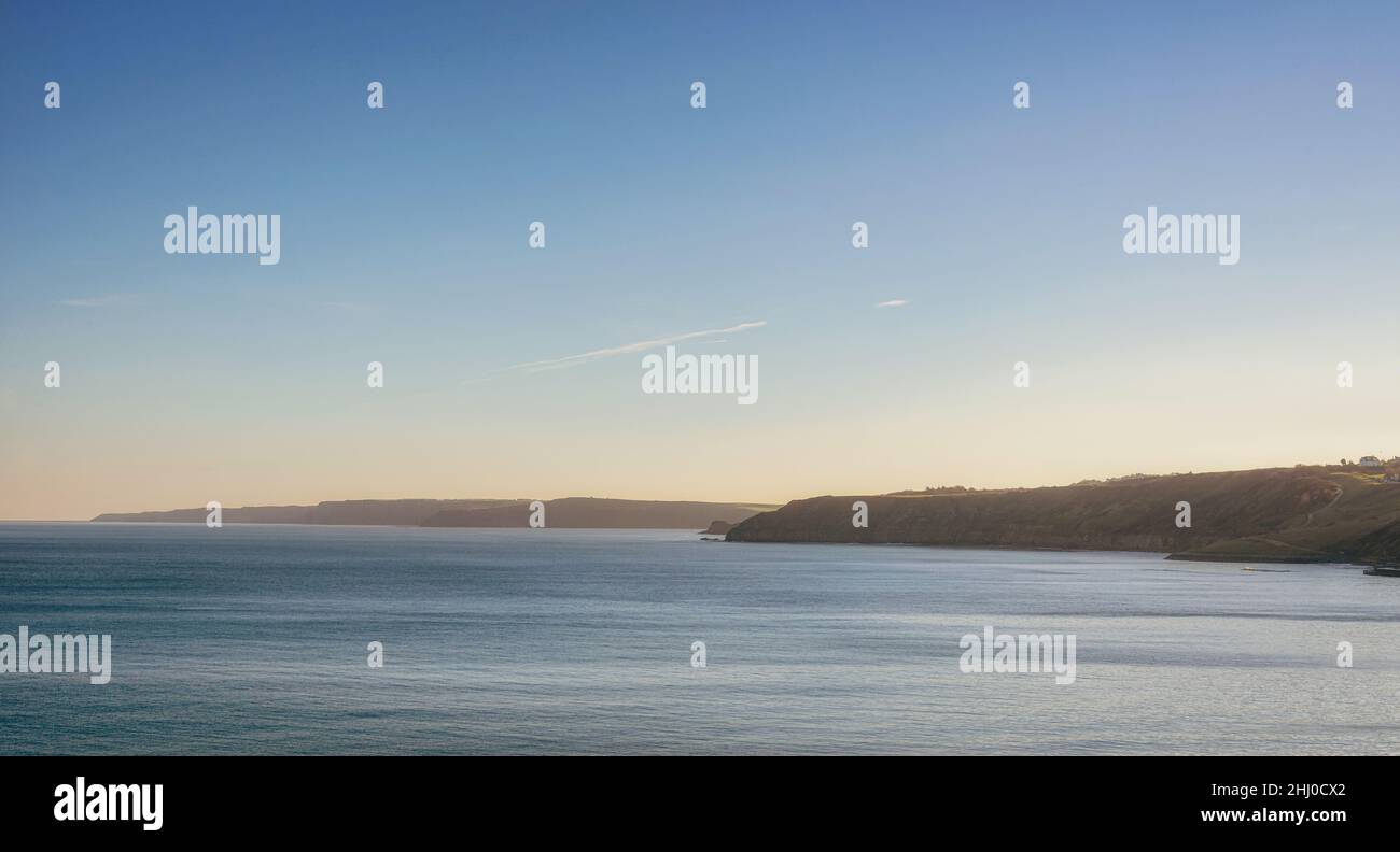 Panoramic view of a seaside bay. Cliffs are on one side stretching to ...