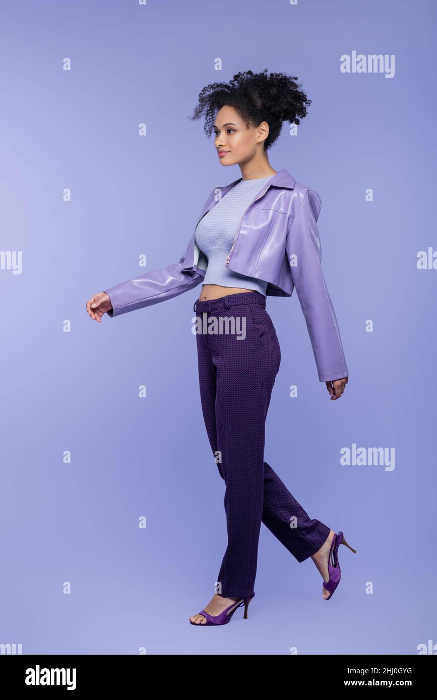 full length of curly african american woman in violet leather jacket ...