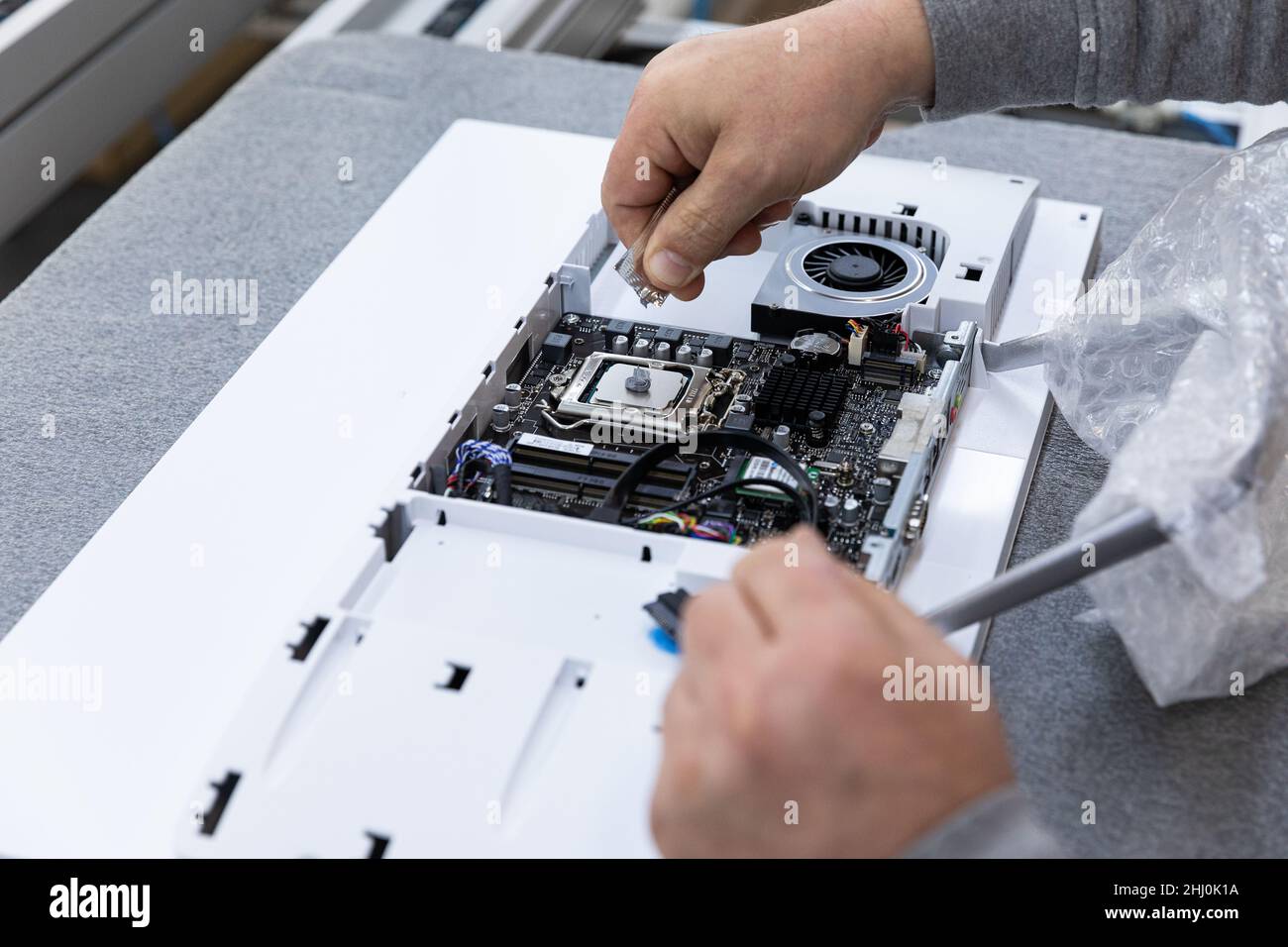 Photo of hands of man who assembles a computer monitor system block on ...