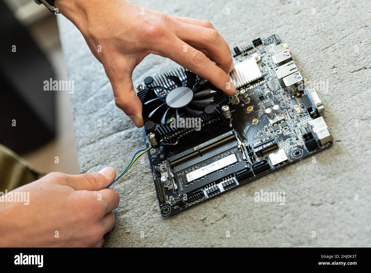 Photo of hand assembles a computer monitor system block on an conveyor ...