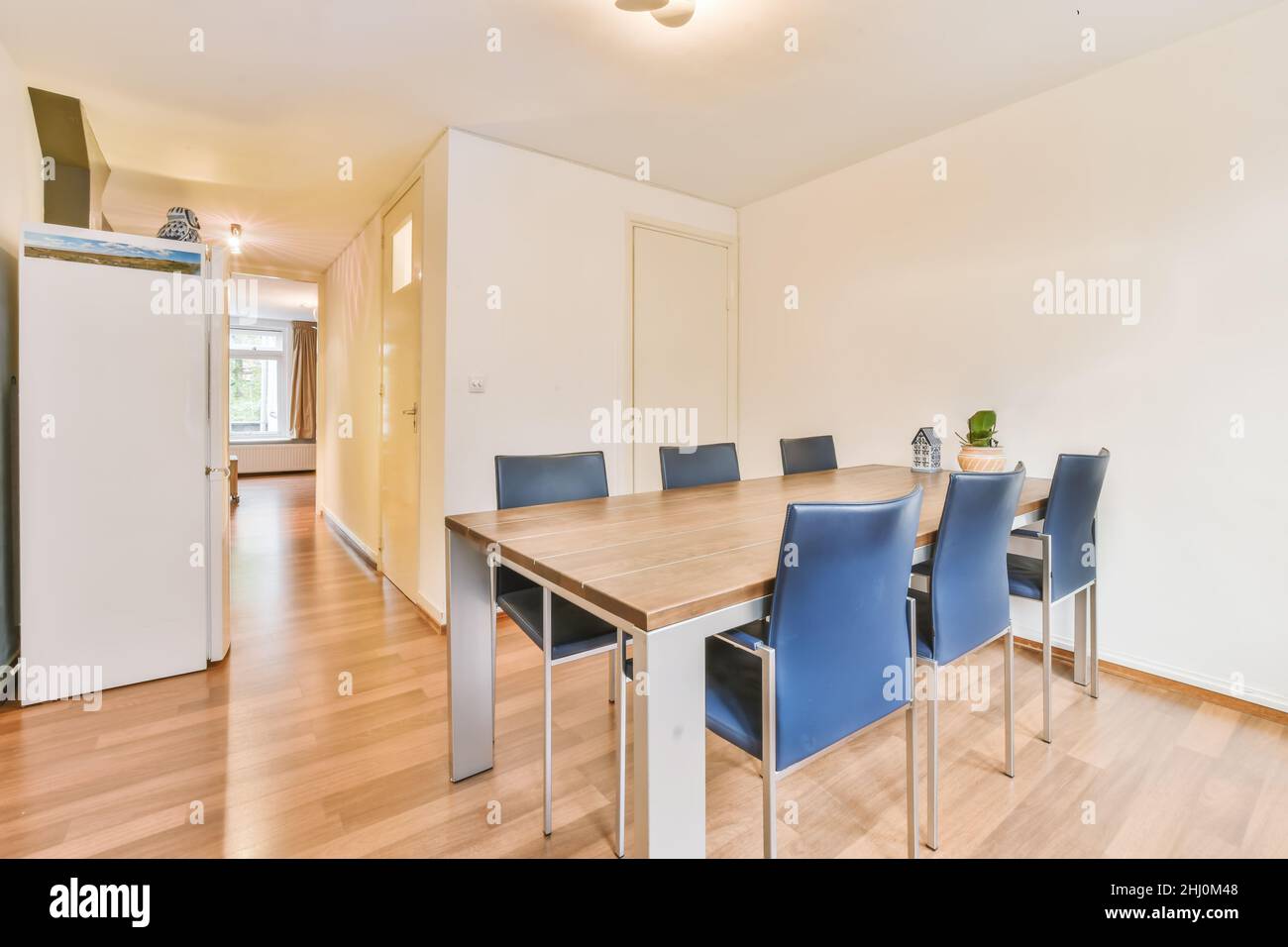 Wooden table and chairs in modern kitchen with large window front in ...