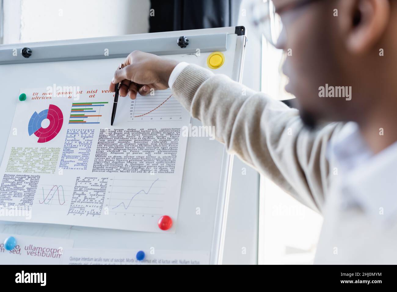 blurred african american man showing infographics with pen on flip ...