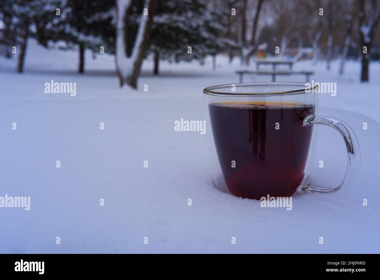 Tea at double-walled glass teacup on snowy desk in winter outdoor Stock ...