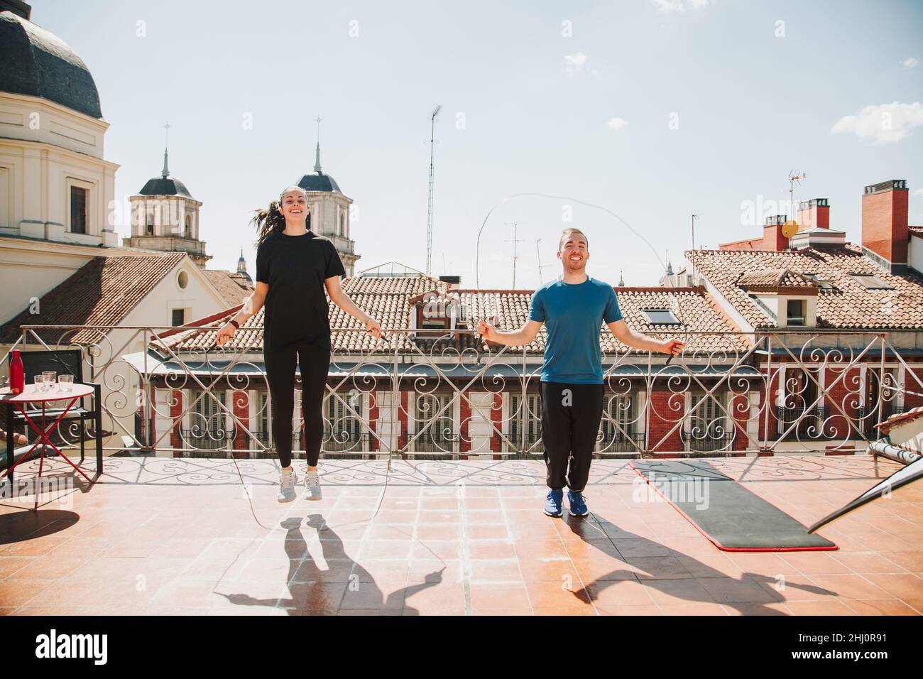 Couple exercising on a building rooftop terrace, jumping ropes Stock ...