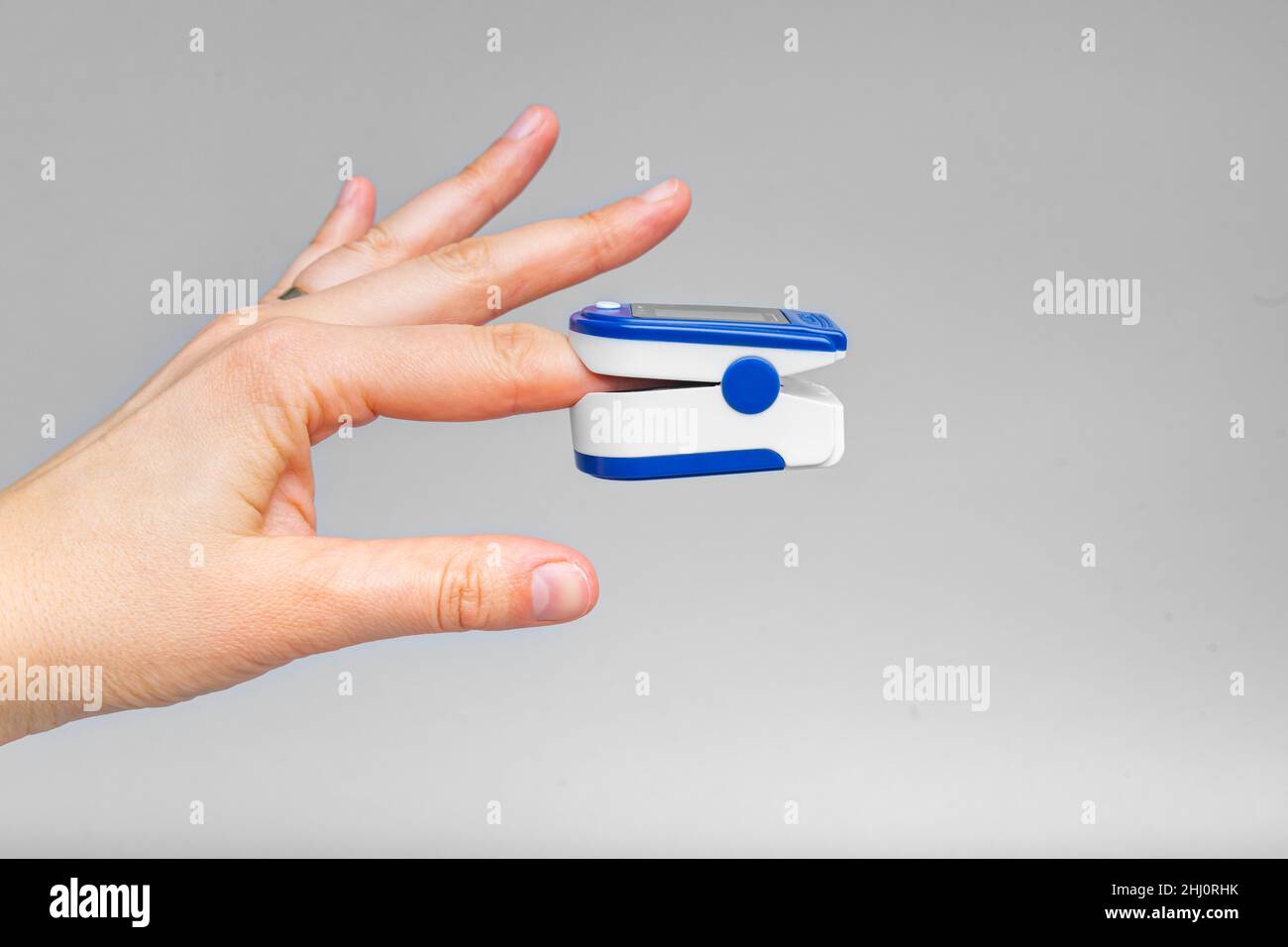 Pulse oximeter on a female hand Stock Photo - Alamy