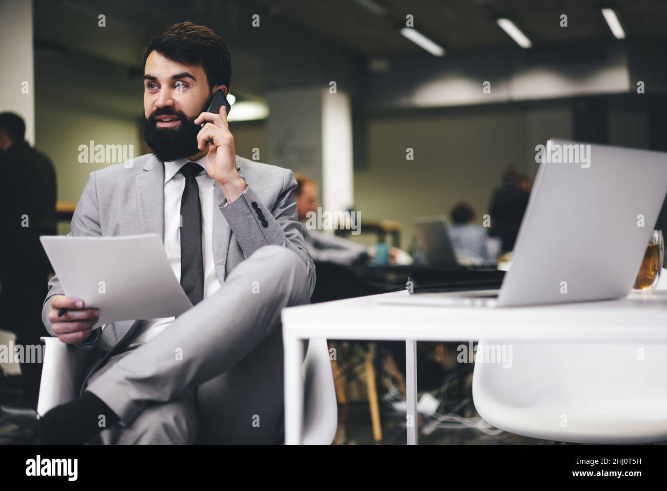 Positive businessman talking on smartphone during work Stock Photo - Alamy