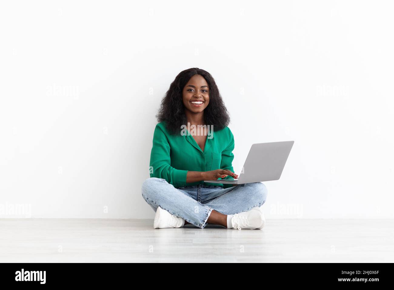 Happy pretty black woman with laptop on white Stock Photo - Alamy