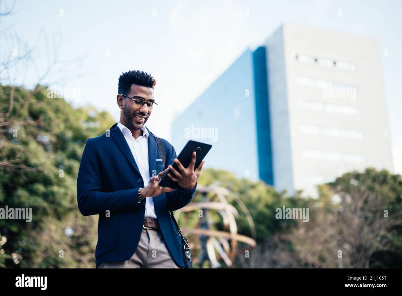 Smiling young black business man using a tablet Stock Photo - Alamy Smiling young black business man using a tablet Stock Photo - Alamy