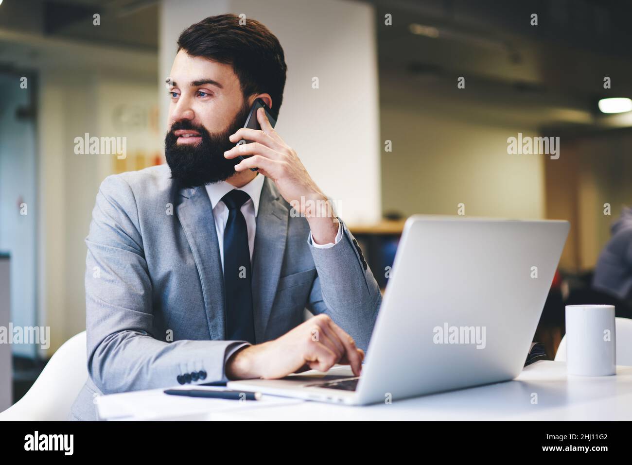 Positive businessman speaking on smartphone during work Stock Photo - Alamy