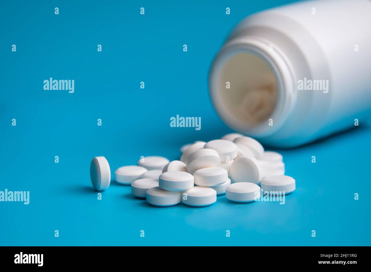 white pills or tablets for virus on blue background Stock Photo - Alamy