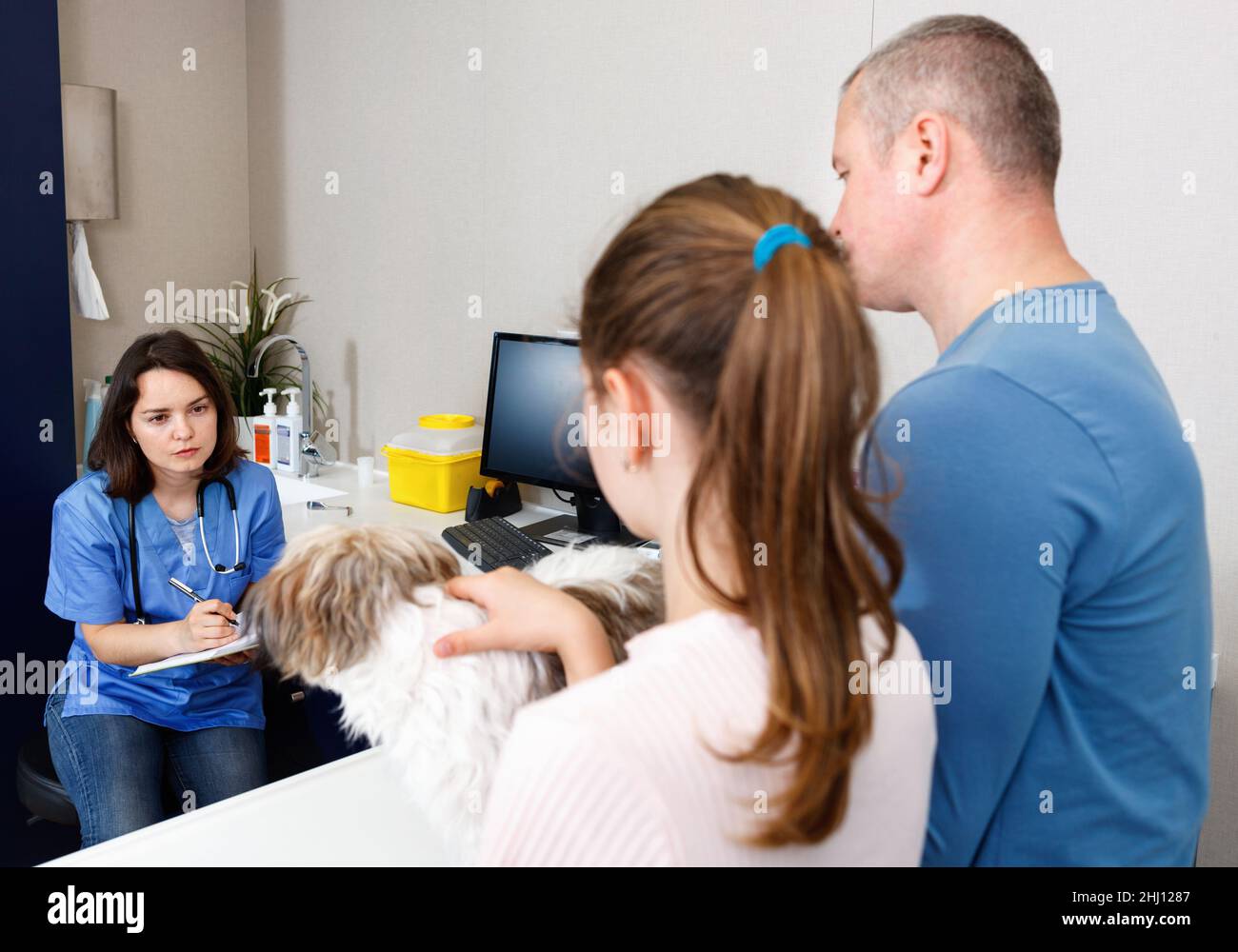 Professional woman veterinarian consulting anxious father and daughter ...