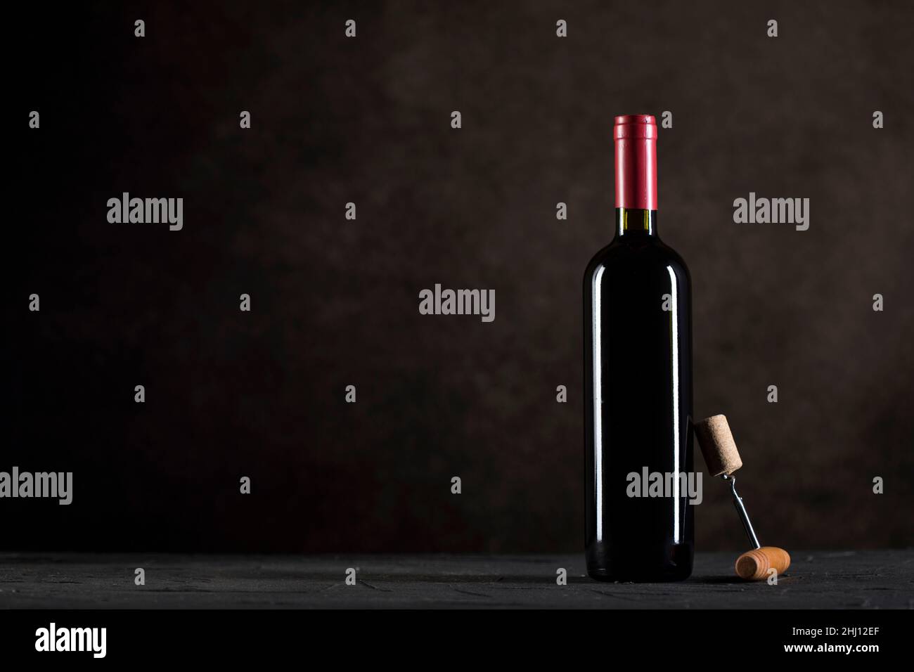 Red Wine buttle and corkscrew on dark background with copy space Stock ...