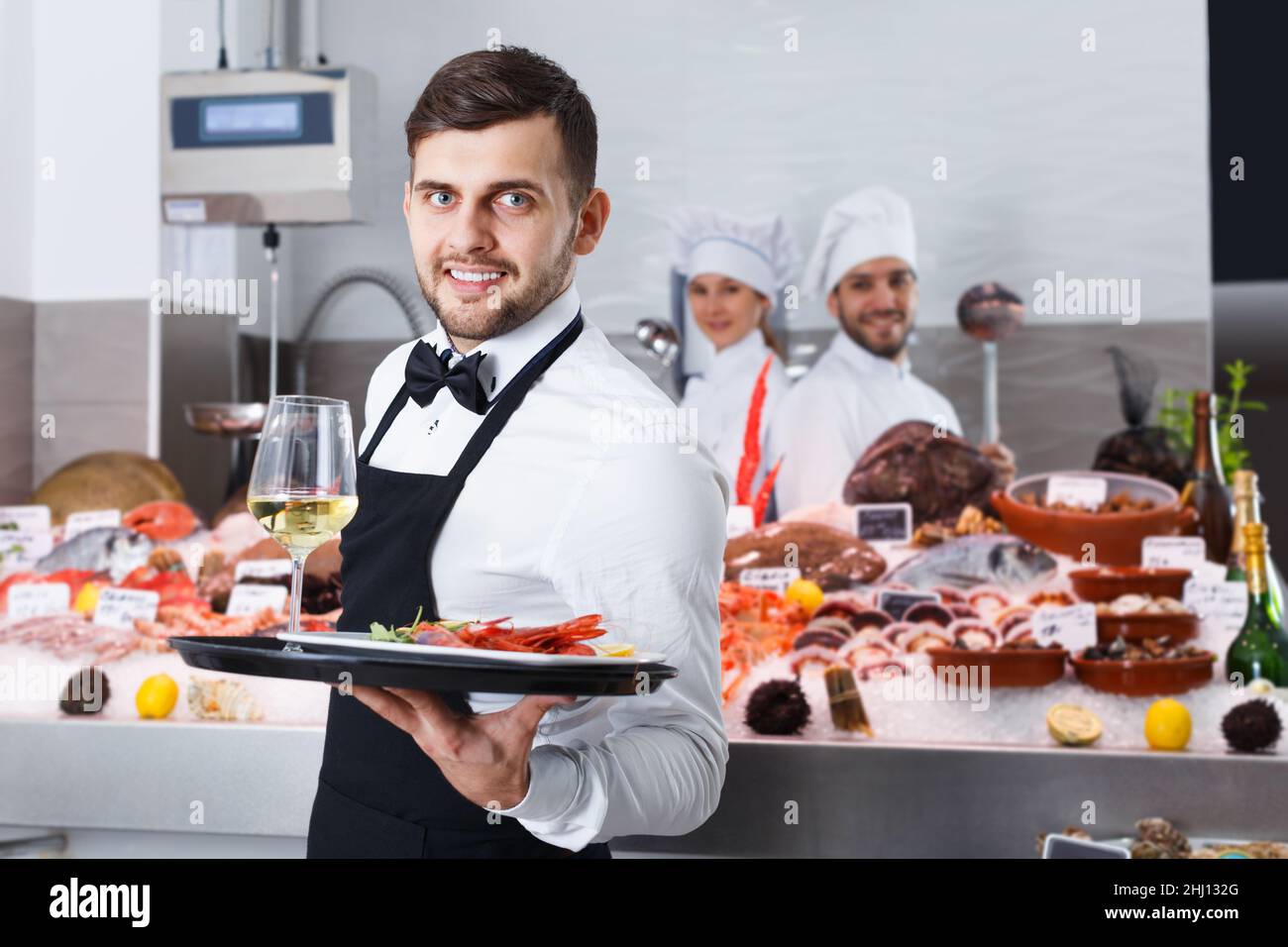 Portrait of smiling waiter with serving tray offering dishes Stock ...