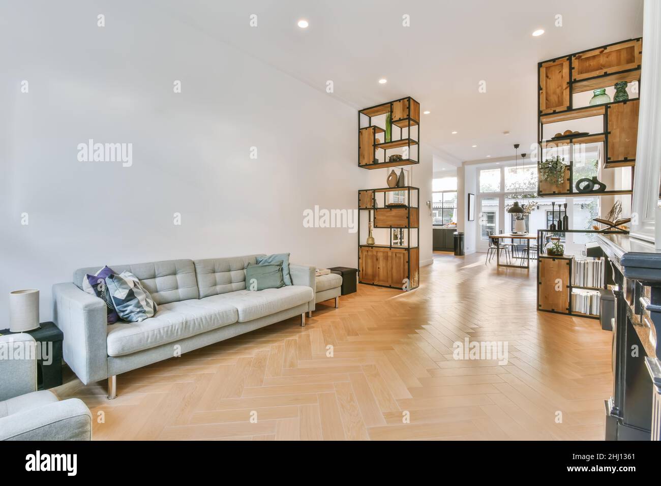 Amazing living room area with light sofa and full-length shelves Stock ...