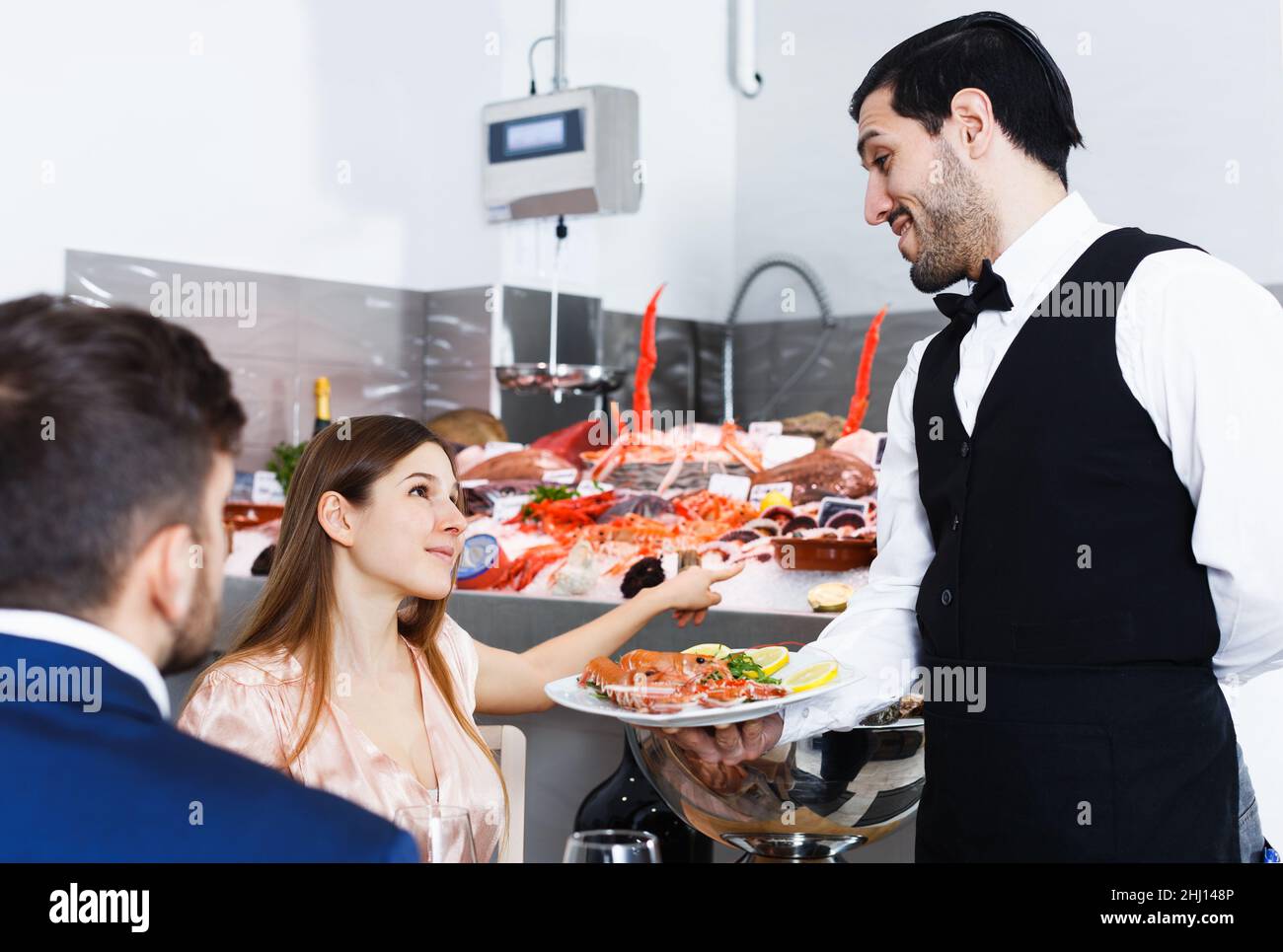 girl asking waiter to cook fresh seafood from showcase Stock Photo - Alamy
