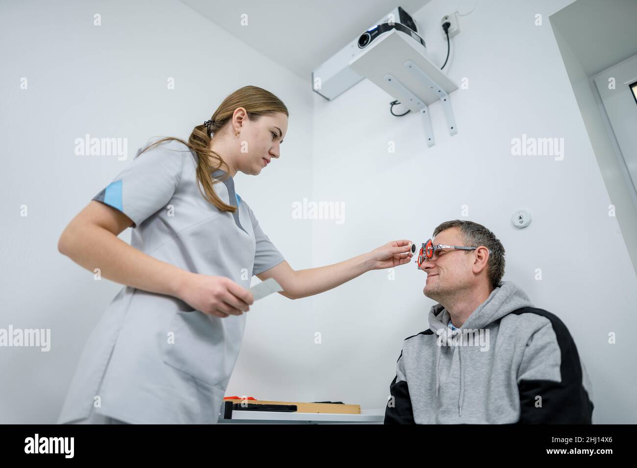 Examining patient vision. Eye exam. Optometrist checking patient ...