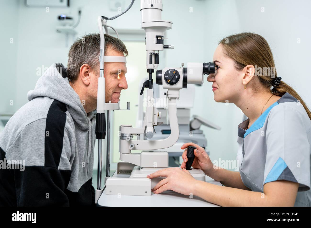 Optometrist examining the eyes of a male patient in a modern ...