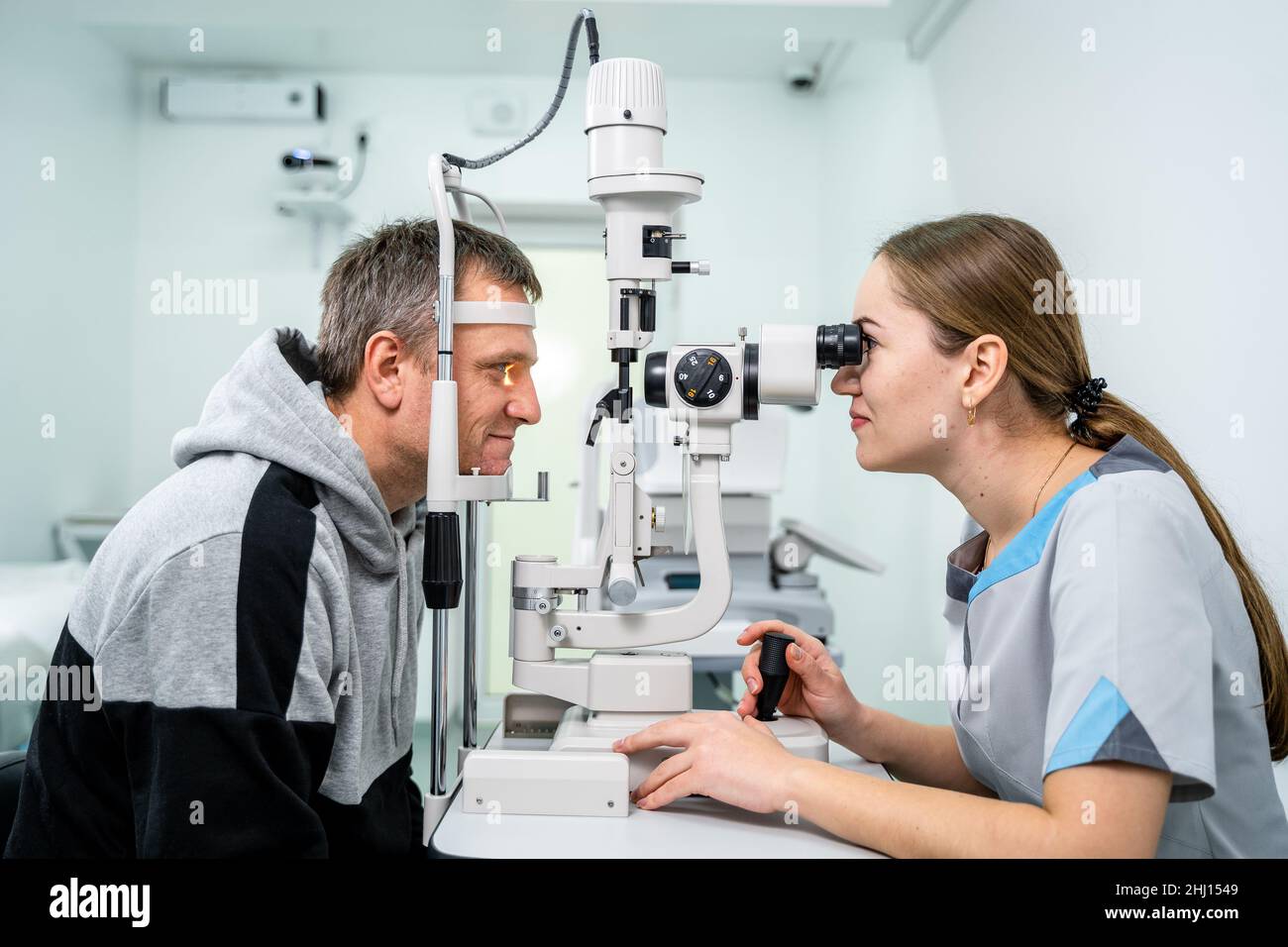 Ophthalmologist and patient testing eyesight. Man doing eye test with ...