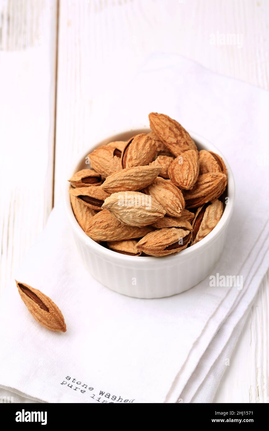 almonds in shell on a white wooden background Stock Photo - Alamy