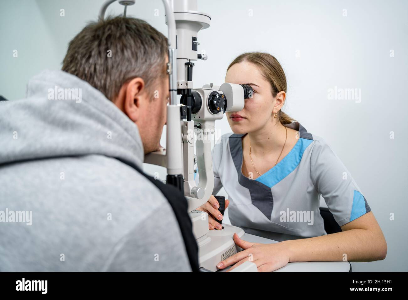Doctor and patient in ophthalmology clinic. Male patient checking ...