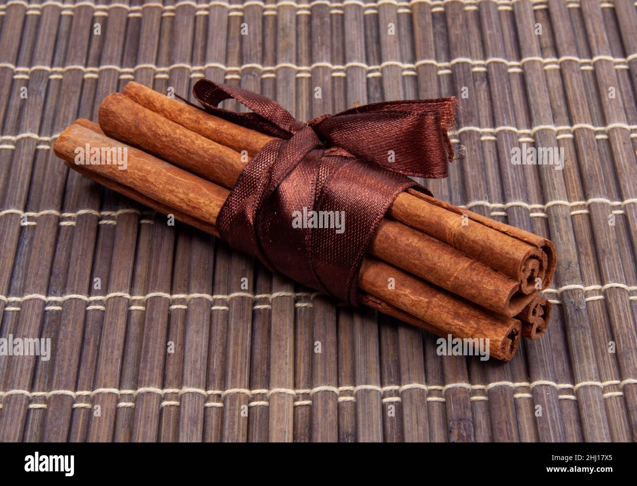Dried sticks of cinnamon natural spices on bamboo mat Stock Photo - Alamy