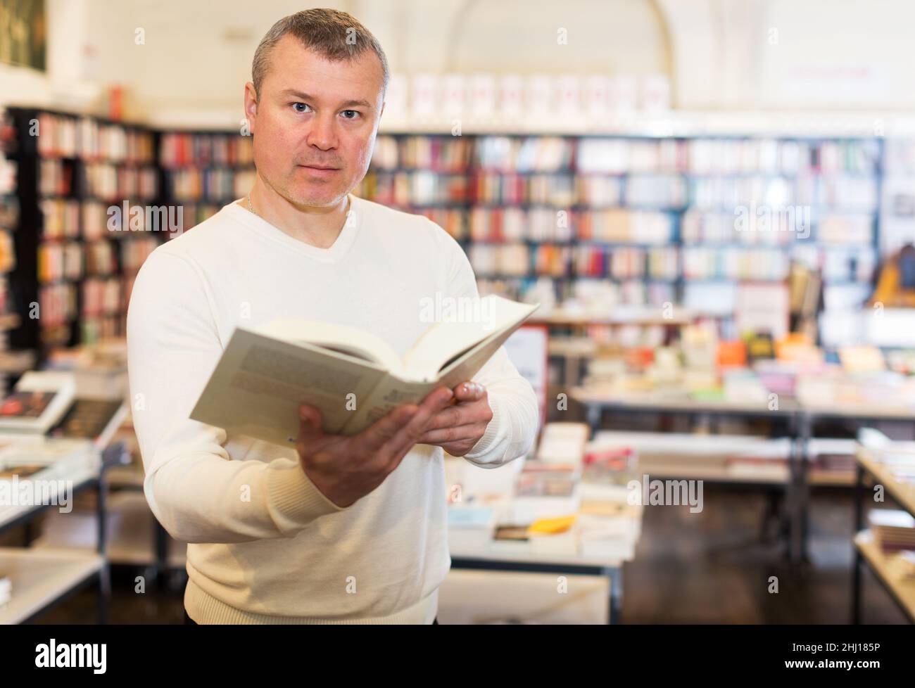 Male reading books in bookshop Stock Photo - Alamy
