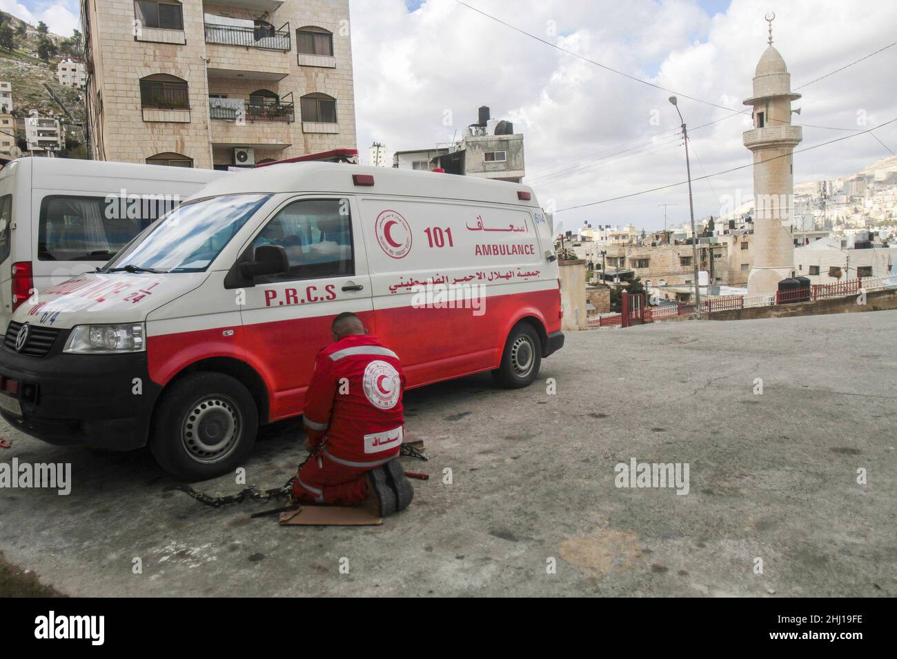 A Palestinian ambulance officer puts cover for the ambulance tires in ...