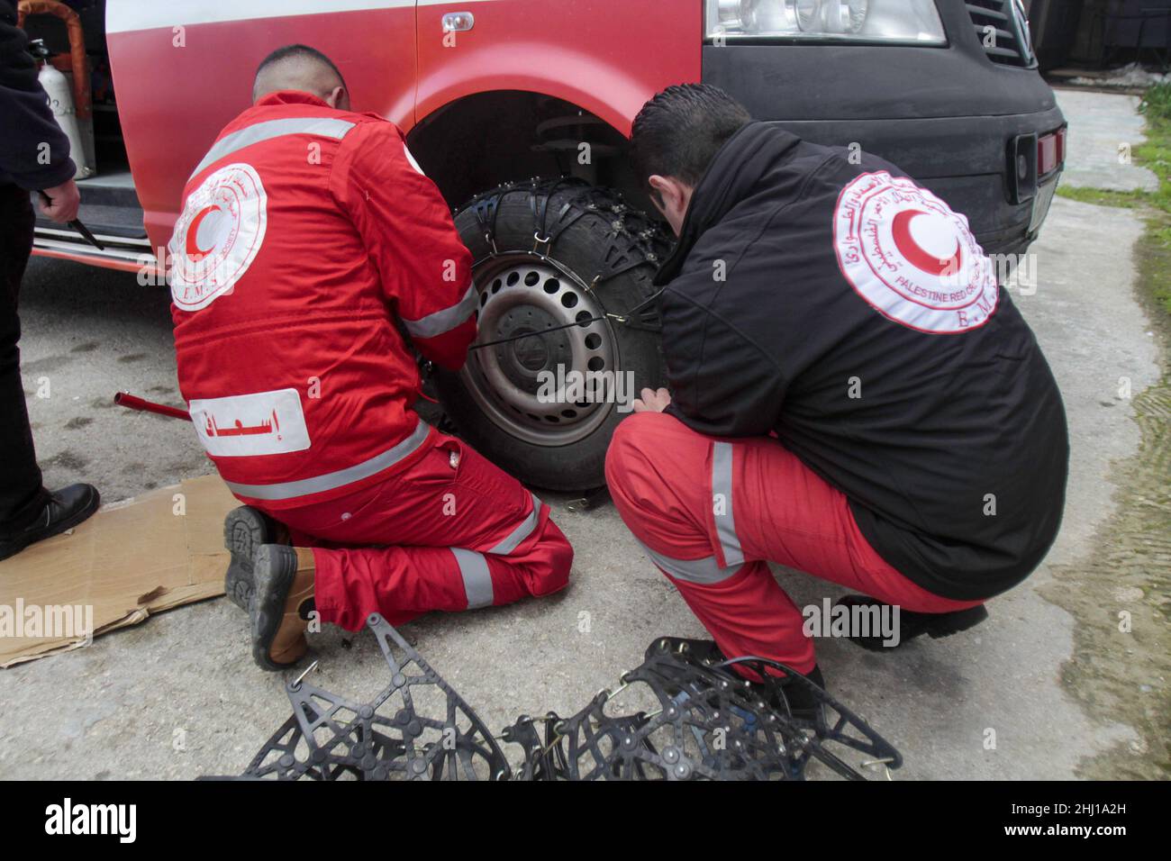 Palestinian ambulance officers put cover for the ambulance tires in ...