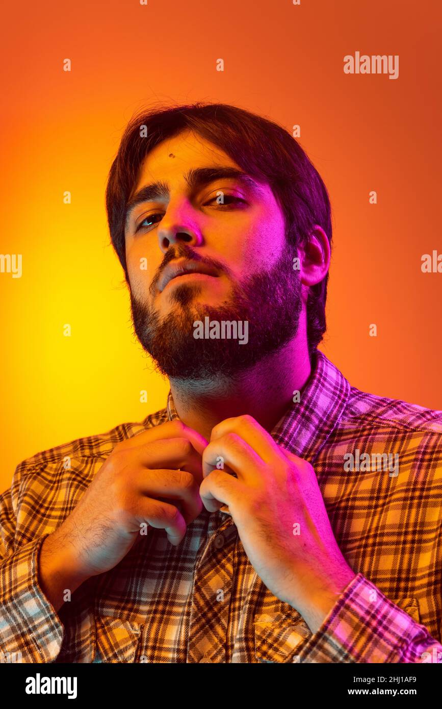 Cropped portrait of young boy posing, looking at camera and fasten a ...