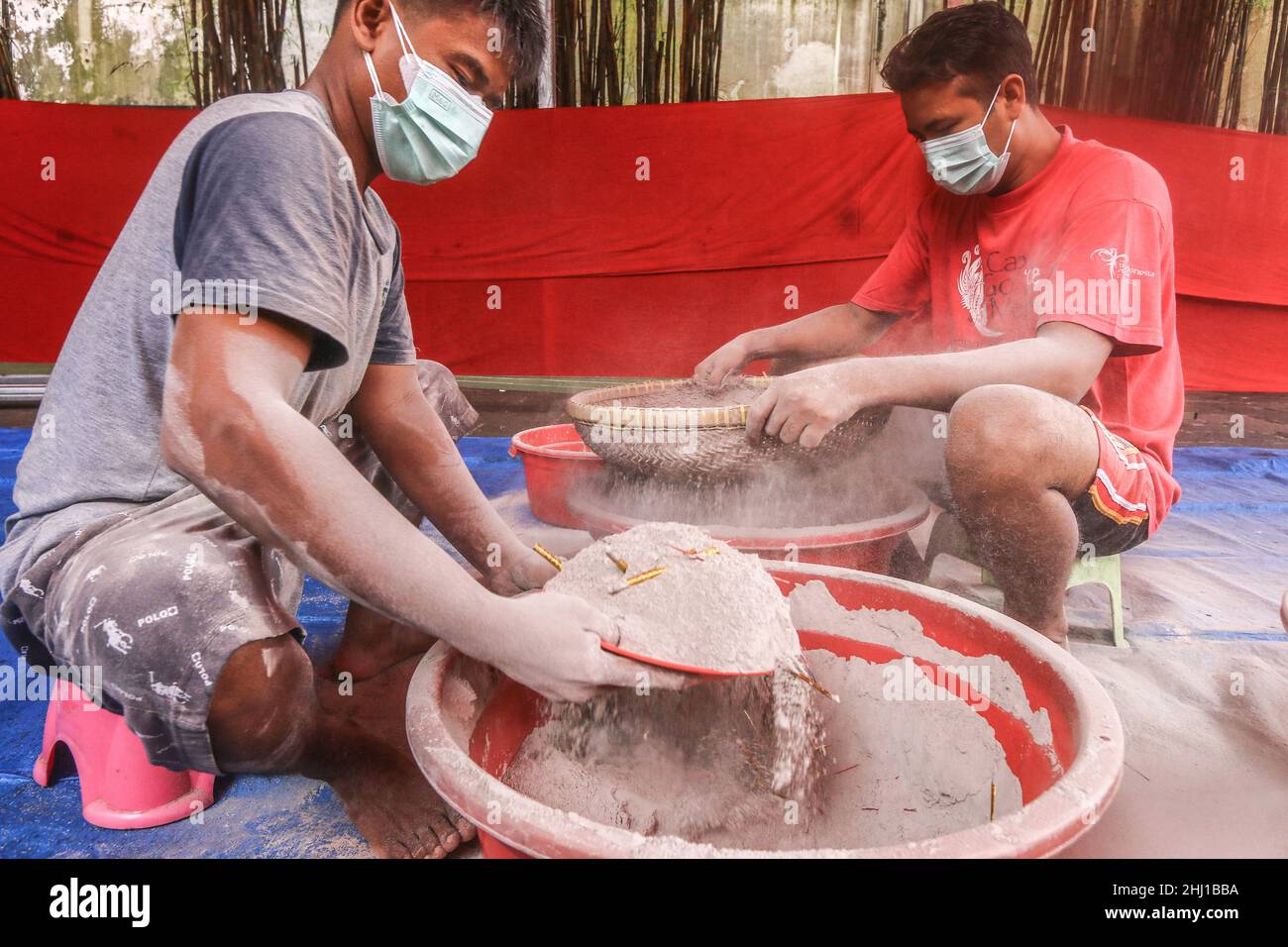 Workers lift ashes during ash sifting ritual upcoming of the Lunar New ...
