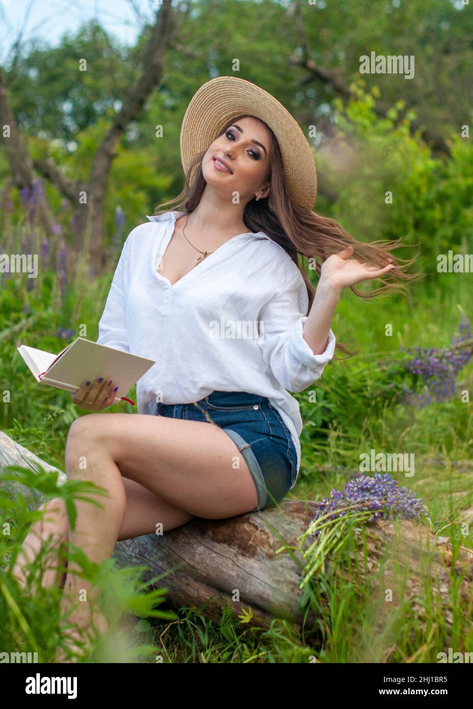 Pretty elegant girl reading book relax on nature field of flowers Stock ...
