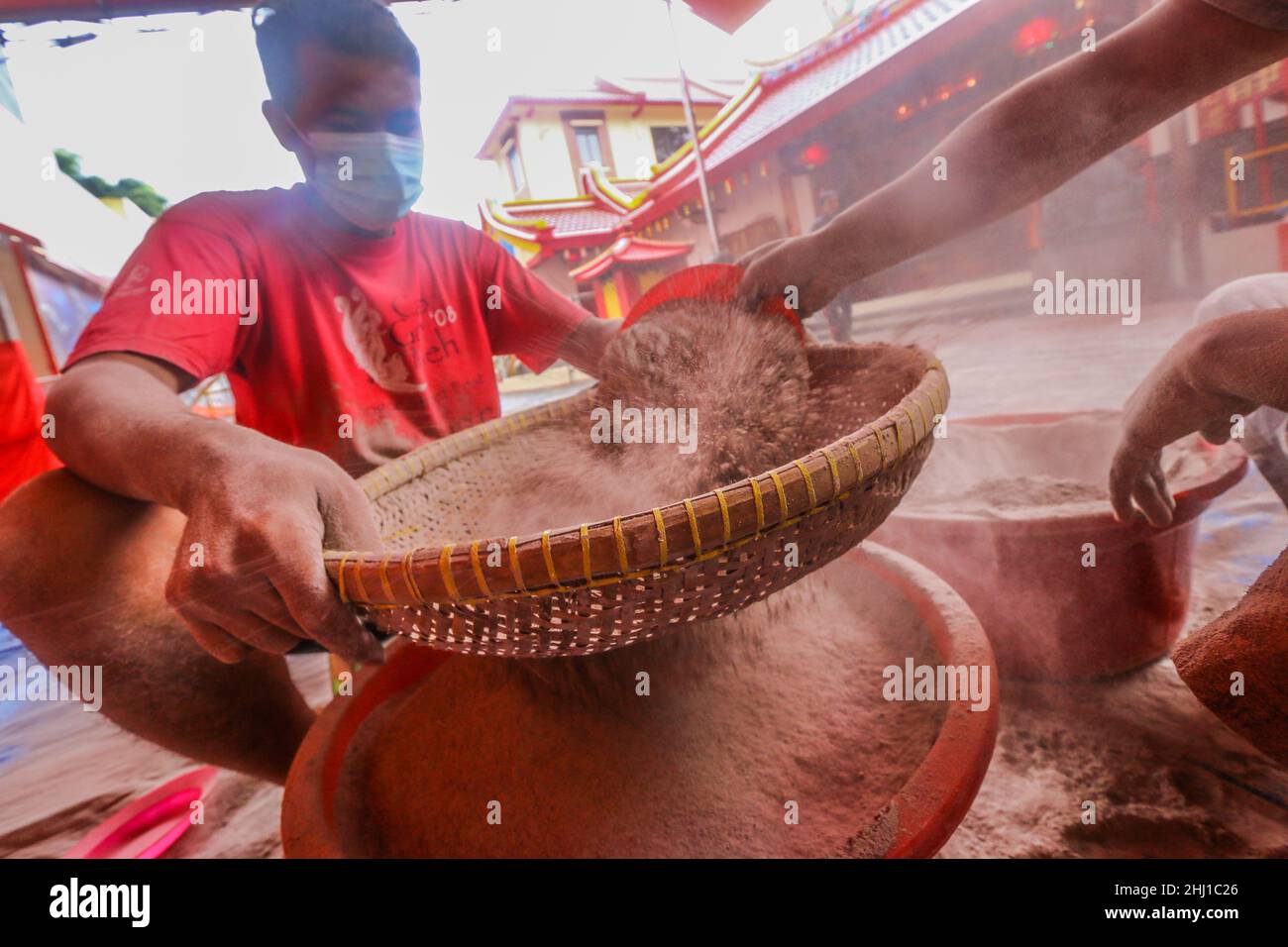 Workers lift ashes during ash sifting ritual upcoming of the Lunar New ...