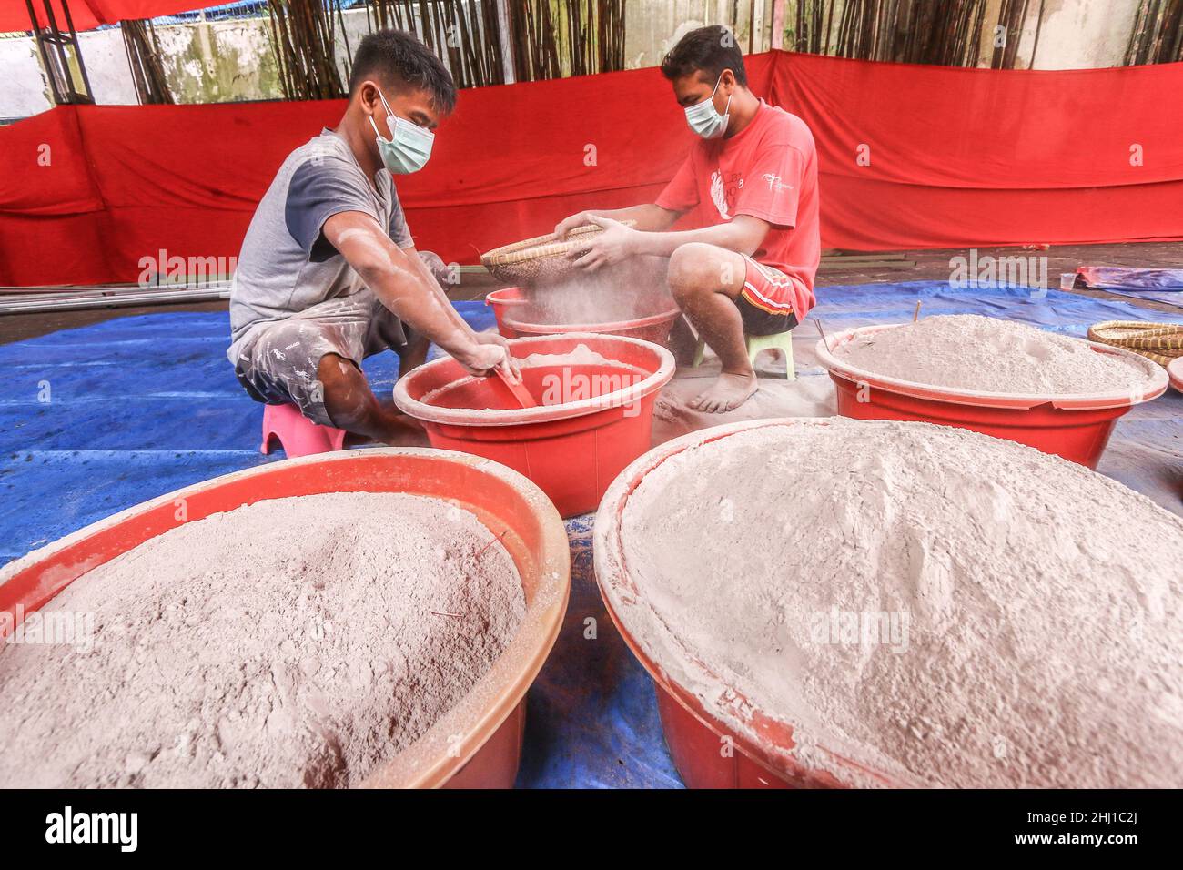 Workers lift ashes during ash sifting ritual upcoming of the Lunar New ...