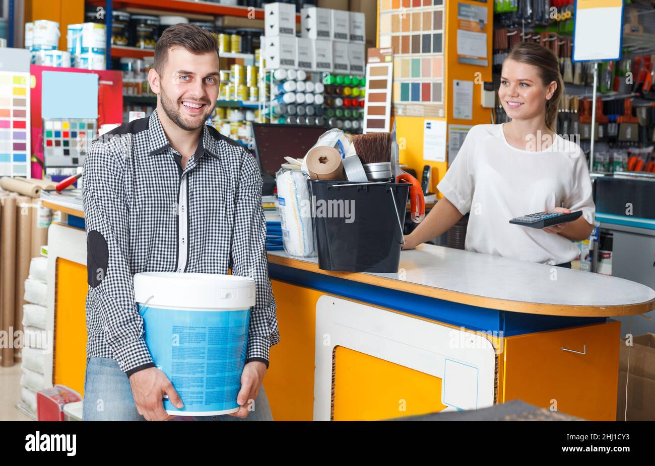 cheerful male customer with tools and seller at cash desk Stock Photo ...