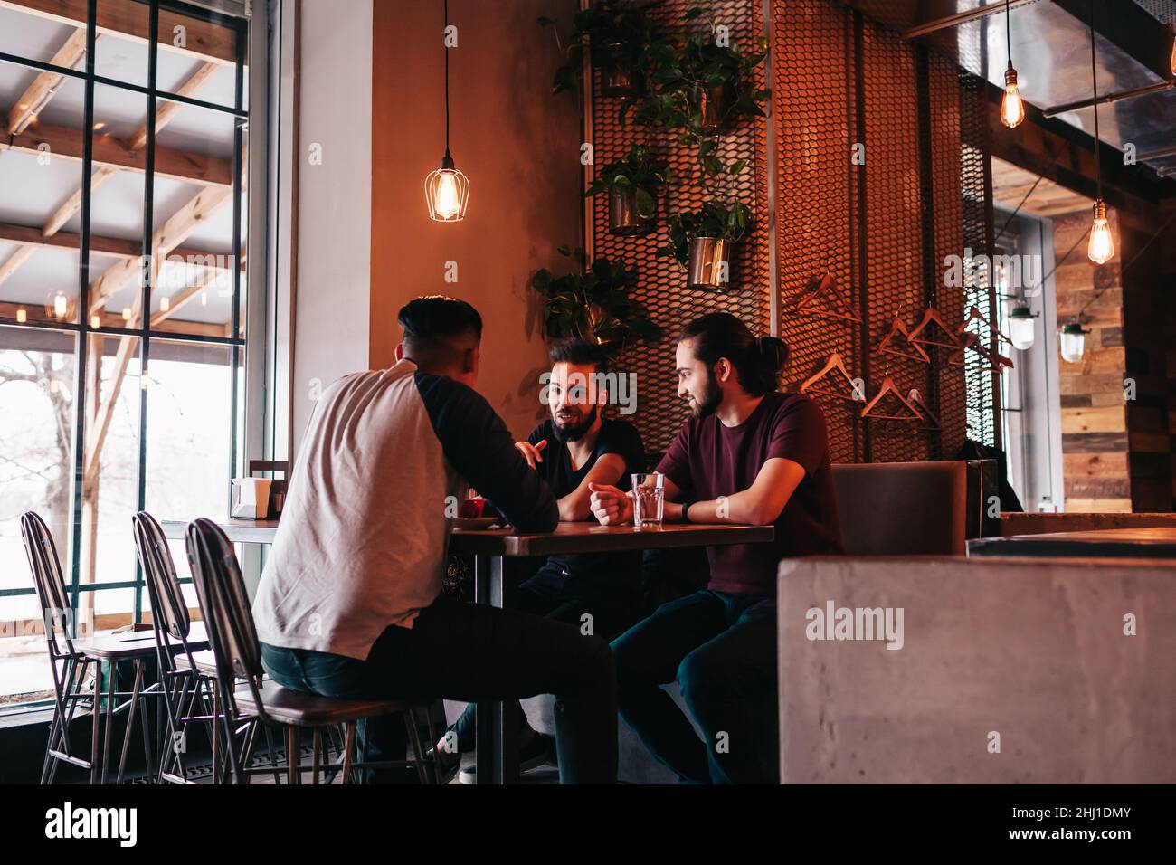 Group of mixed race young men talking in lounge bar. Multiracial ...
