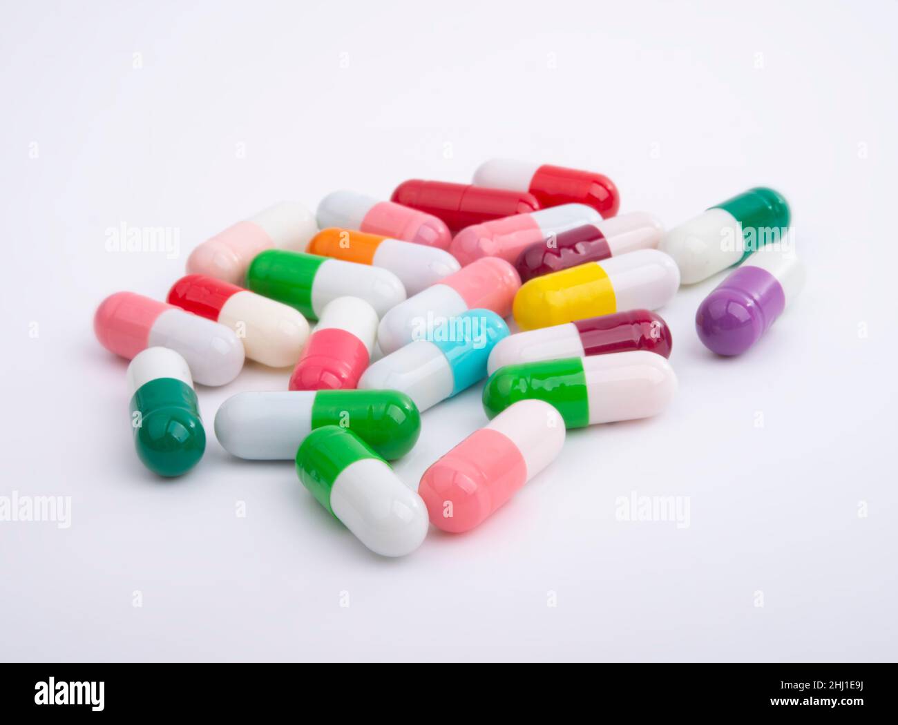 Different color pills on white background Stock Photo - Alamy