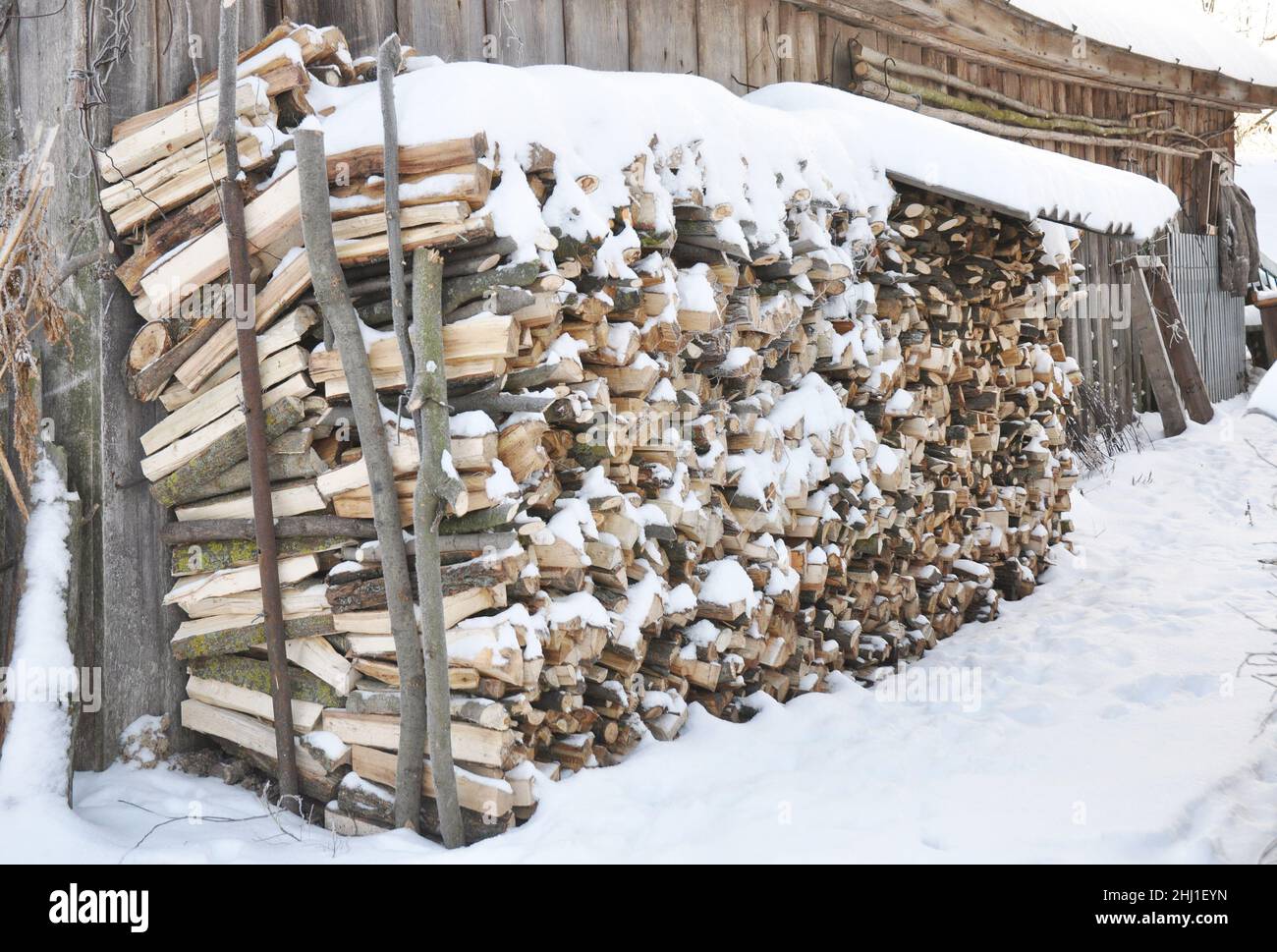 Firewood Snow. The stack of the snowy firewood Stock Photo - Alamy