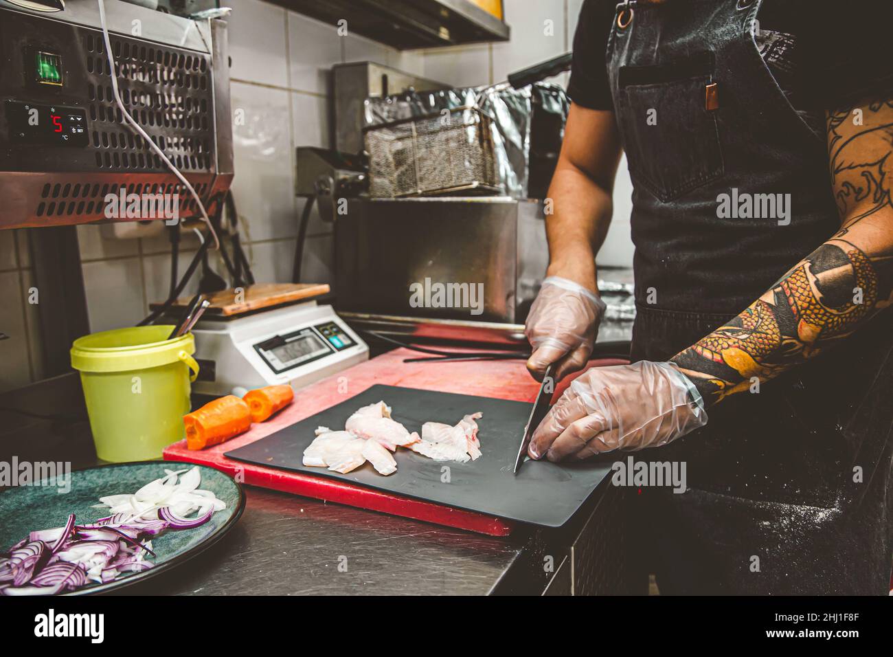 a chef in a restaurant cuts fish for making sushi Stock Photo - Alamy