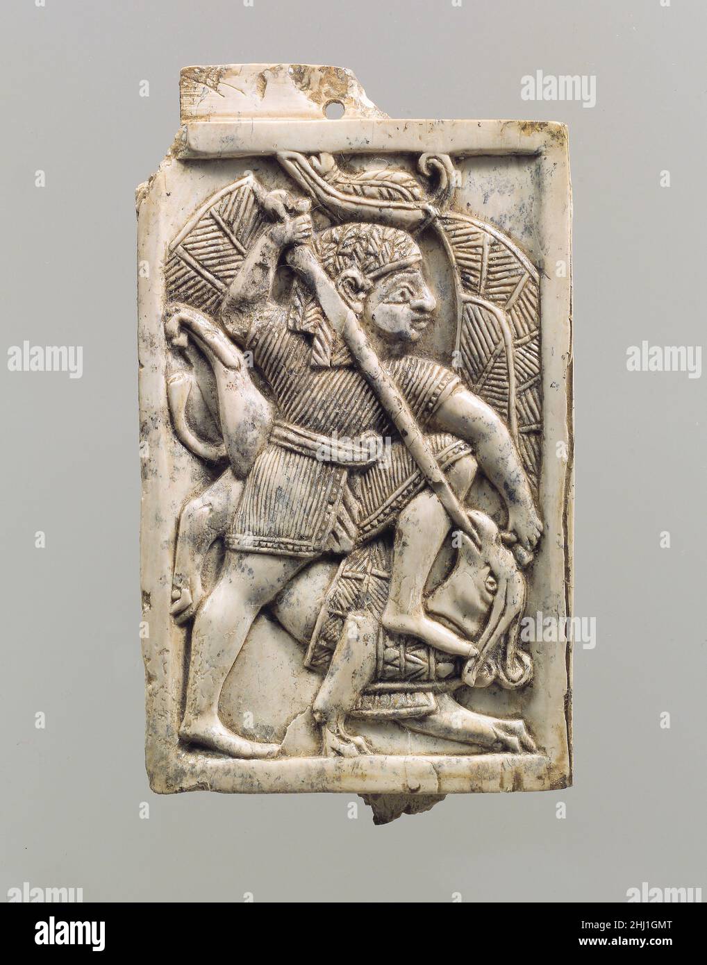 Furniture plaque carved in relief with a male figure slaying a griffin ...