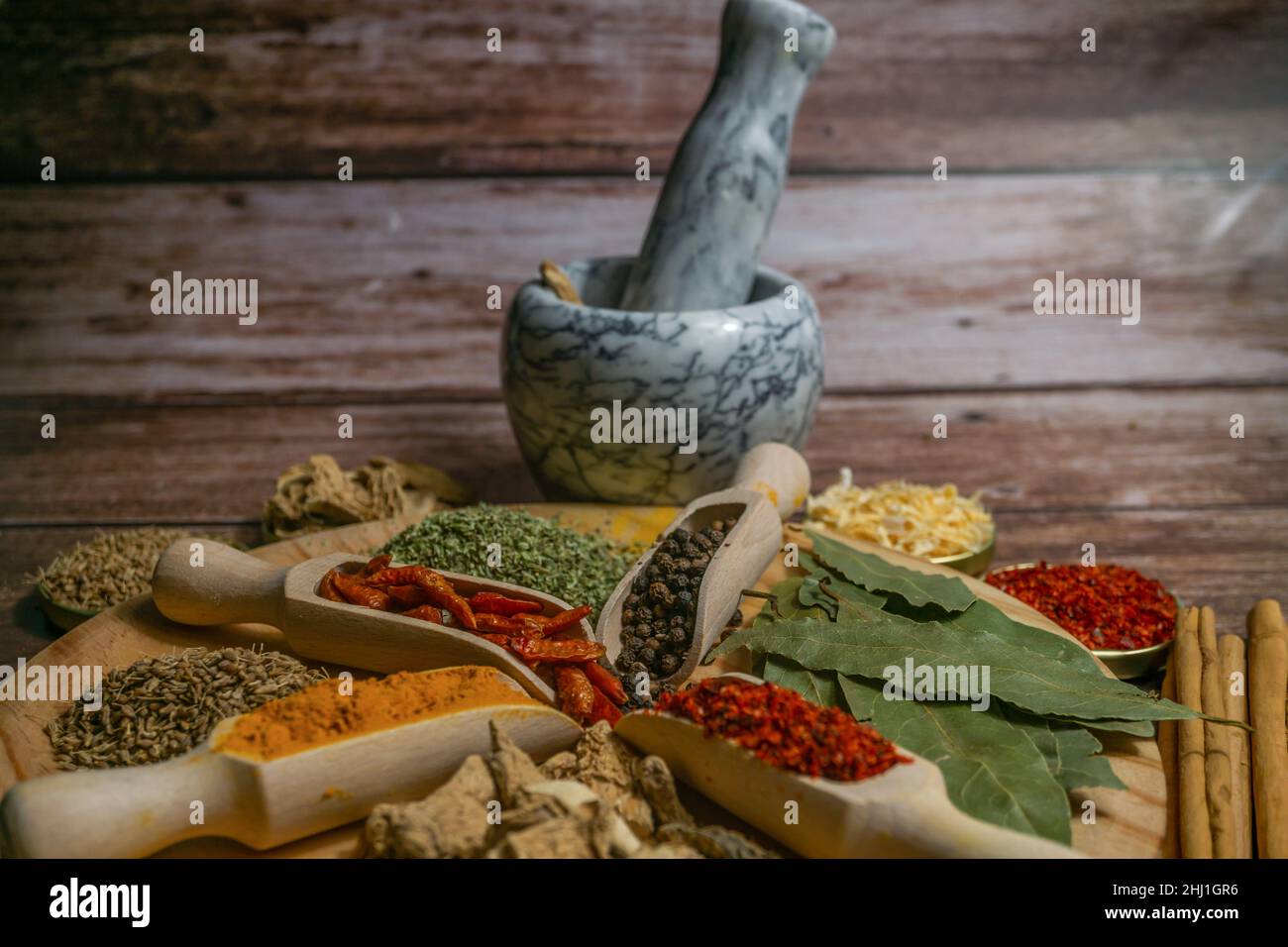 different types of spices in a wooden spoon and mortar Stock Photo - Alamy