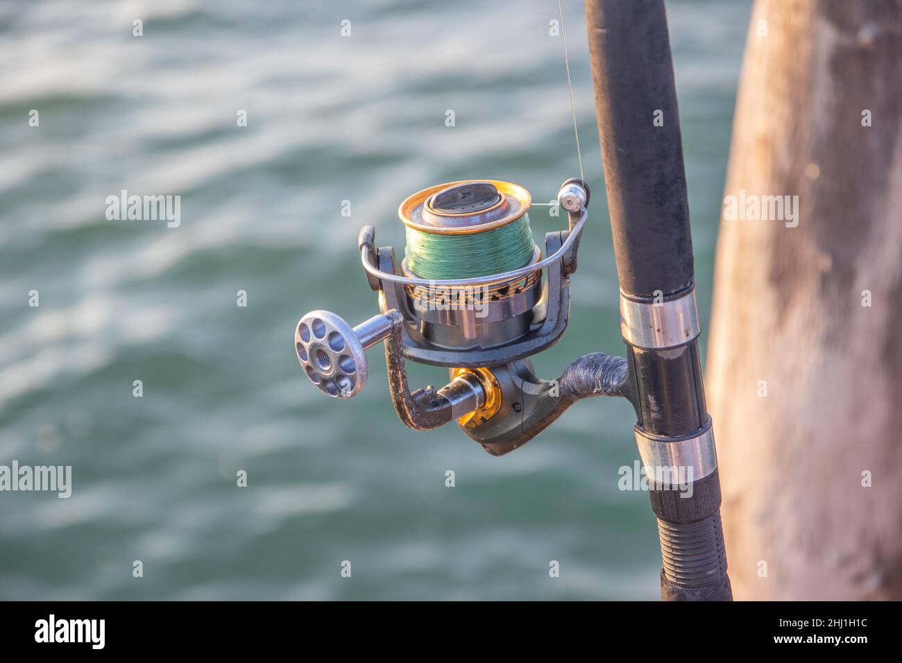 The crank of a fishing rod with reel foot, reel seat, spool, coiled ...