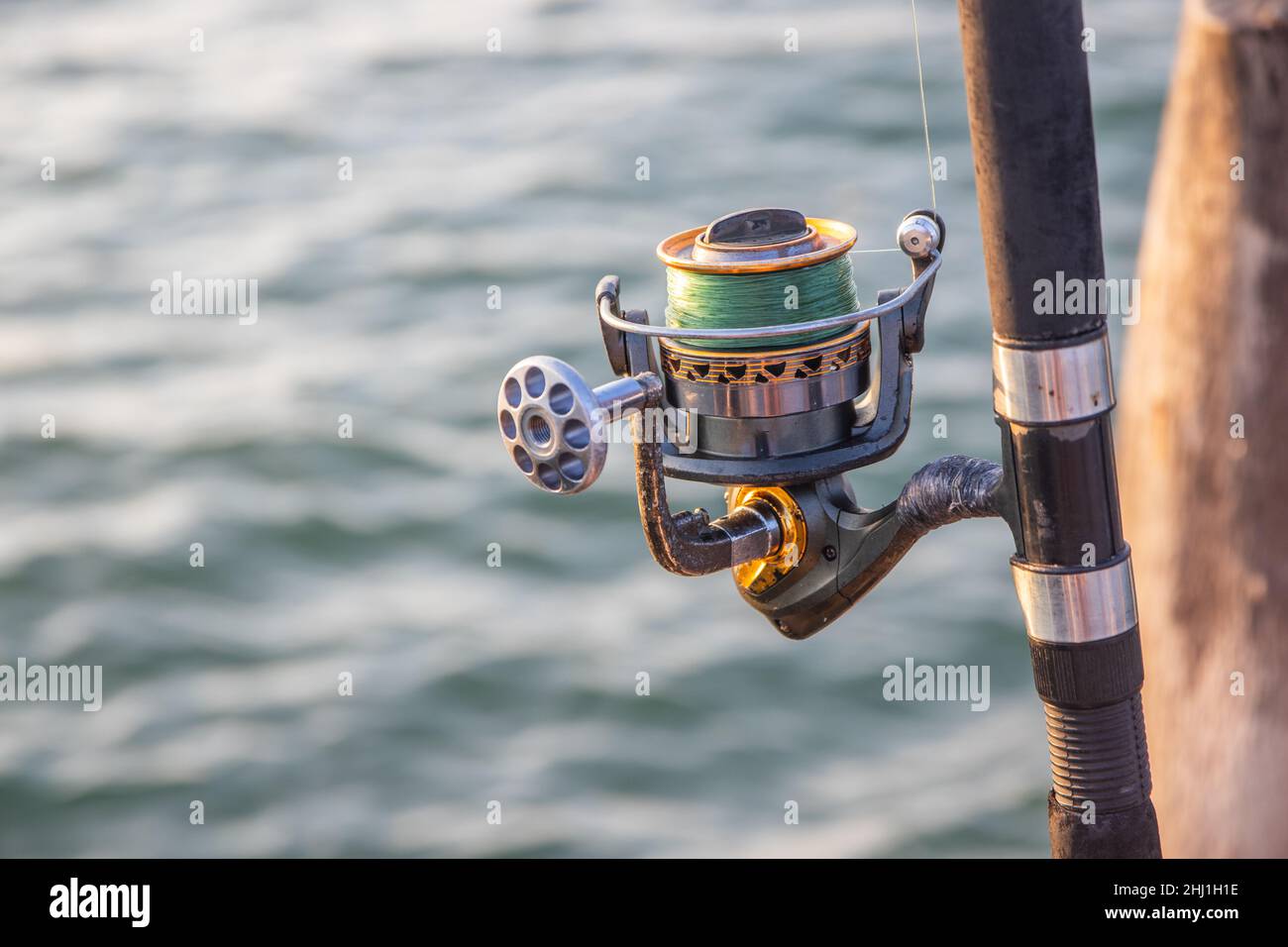 The crank of a fishing rod with reel foot, reel seat, spool, coiled ...