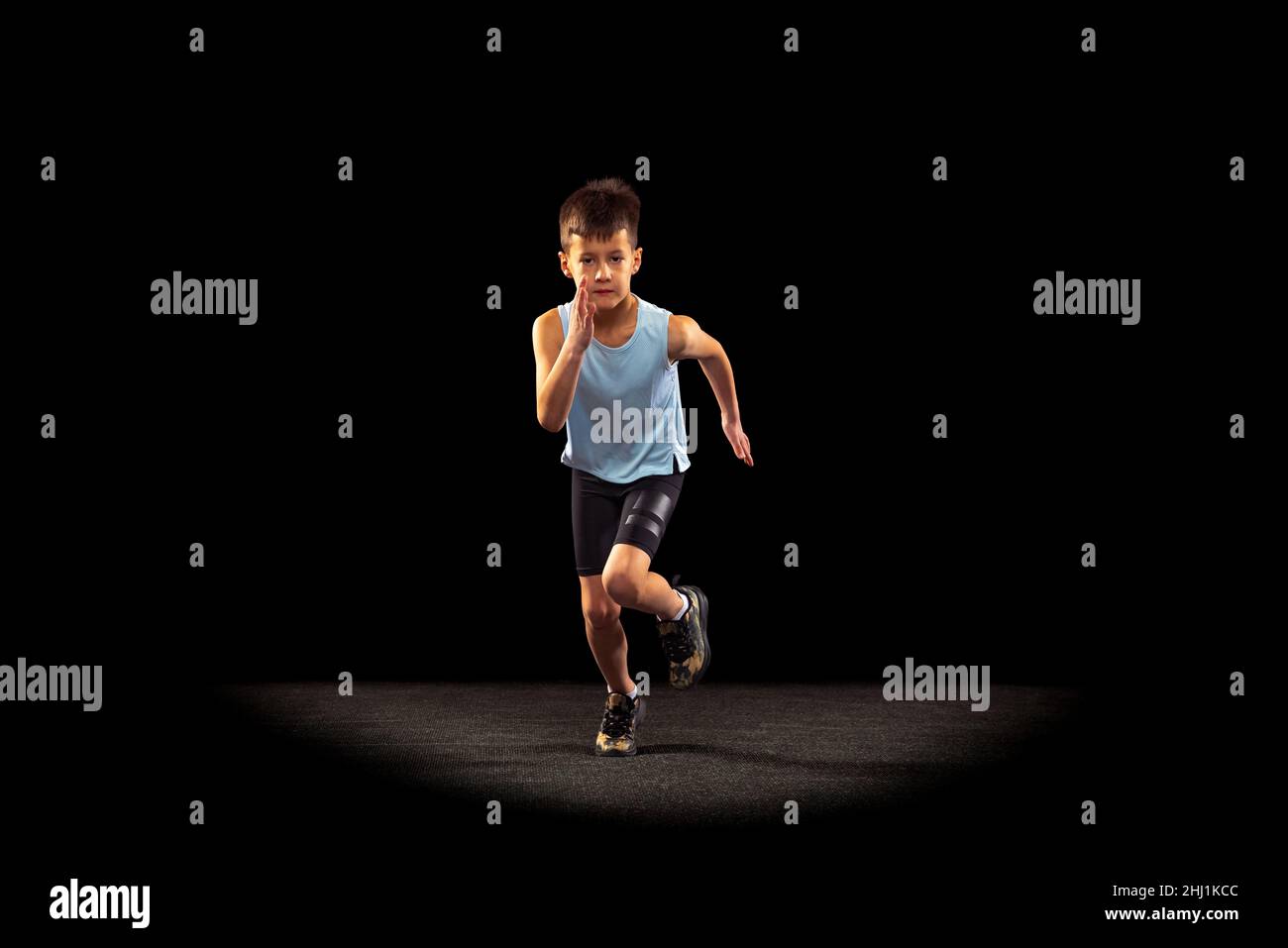 Studio portrait of boy, child, running athlete training isolated over ...